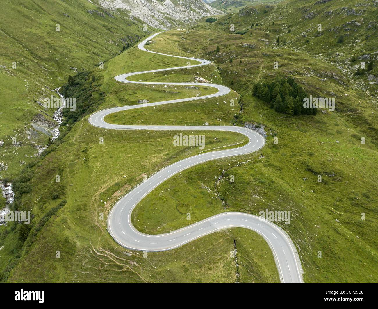 Aerial view of a winding road snakes through the undulating green hills ...