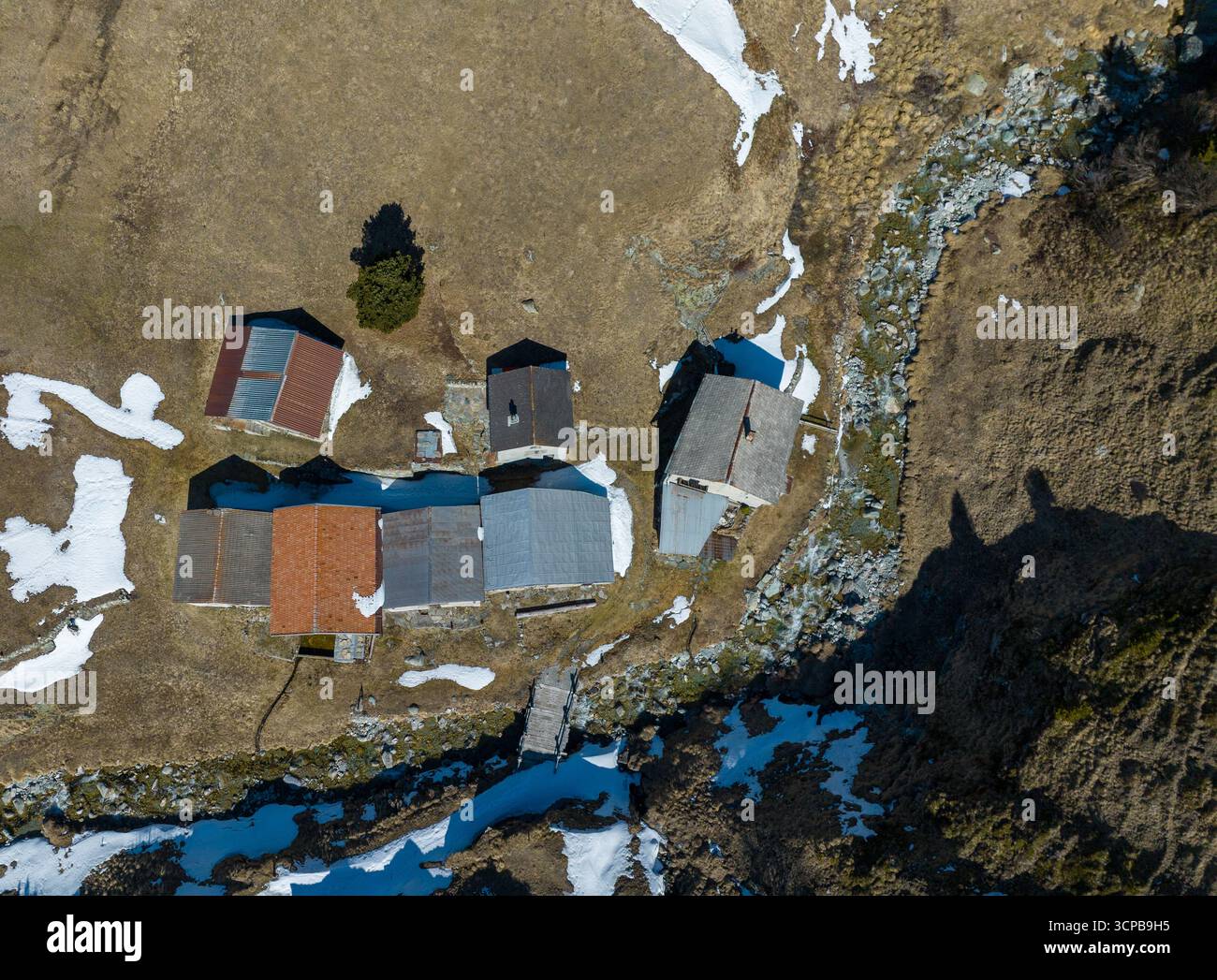 Aerial view of a small cluster of buildings with varied roof colors ...