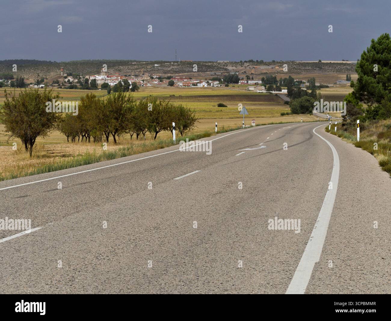 Road downhill winds around an ancient village and continues towards ...