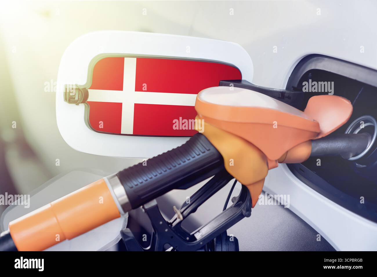 The Danish flag on the lid of the gas tank of a car at a gas station in ...