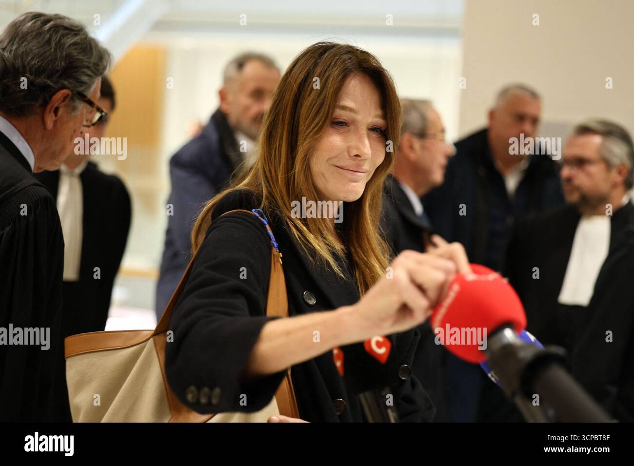 Carla Bruni grabs the windscreen of a Mediapart microphone as her ...