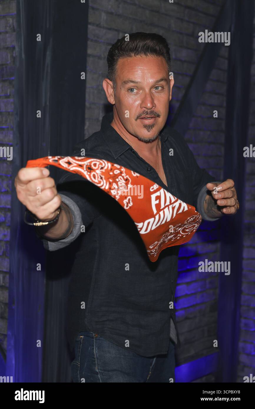 Kevin Alejandro poses with a Fire Country bandana at the CBS Sheriff ...