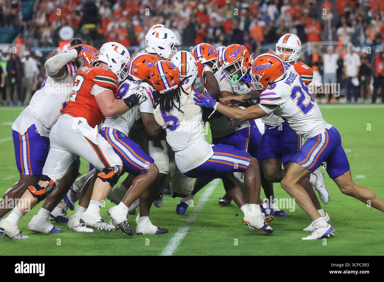 Florida Gators linebacker Myles Graham (5) and teammates tackle a Miami ...