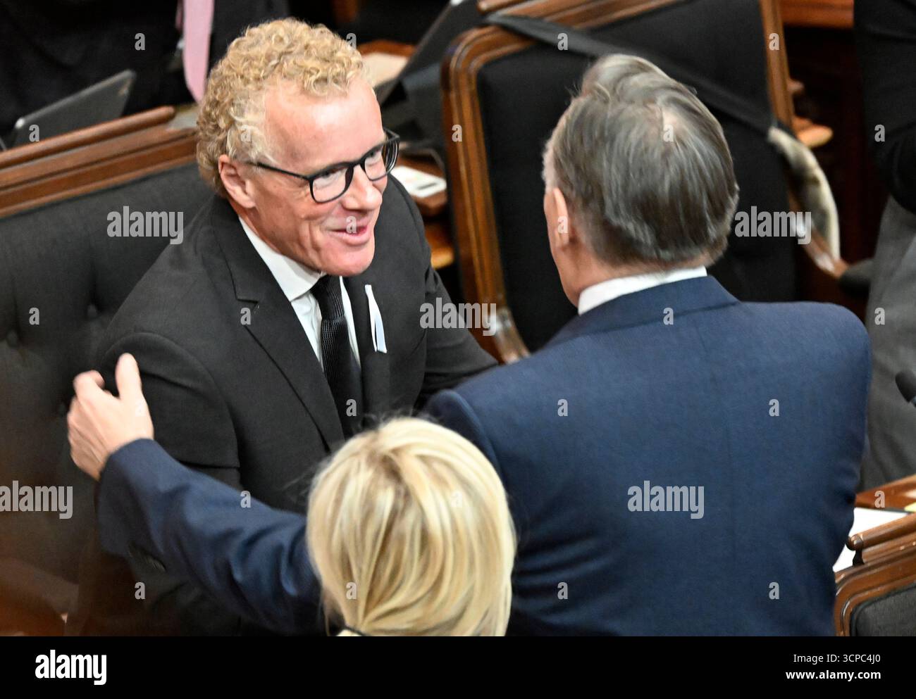 Le ministre du Travail, Jean Boulet, qui est félicité par le premier ...