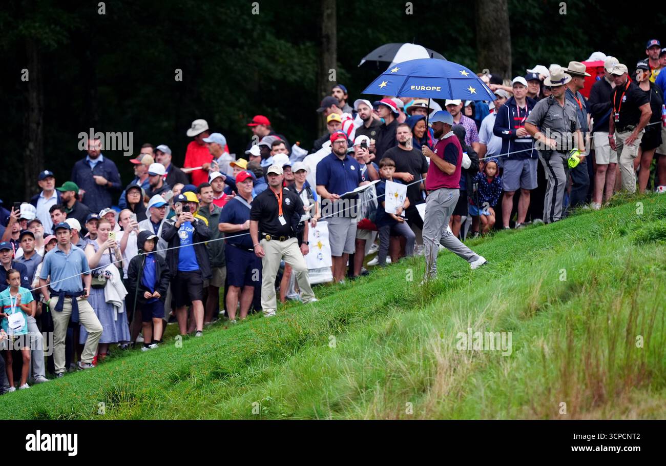Shane Lowry of Team Europe shelters from the rain during a practice ...