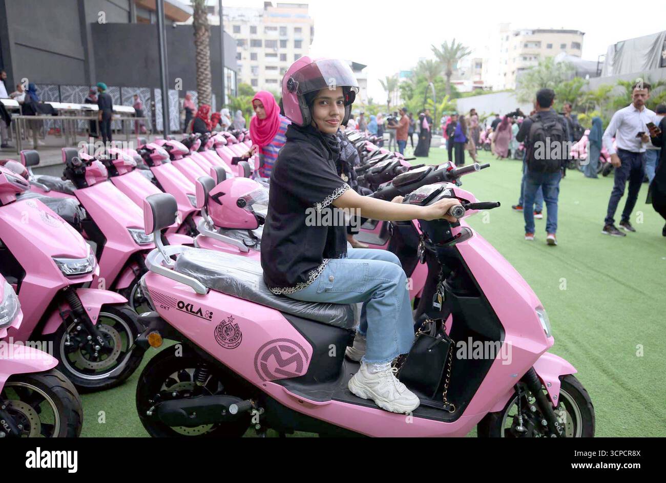 KARACHI, PAKISTAN, SEP 25: Female applicants along the Pink EV Scooty ...