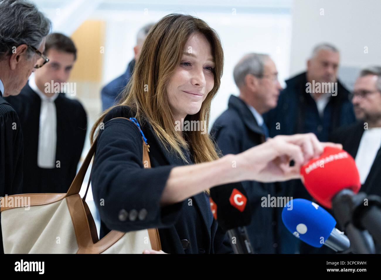 Carla Bruni grabs the windscreen of a Mediapart microphone after her ...