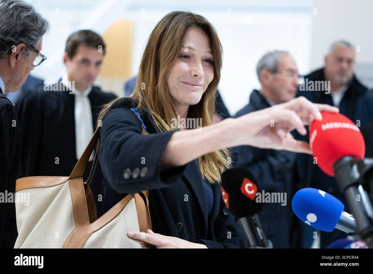 Carla Bruni grabs the windscreen of a Mediapart microphone after her ...