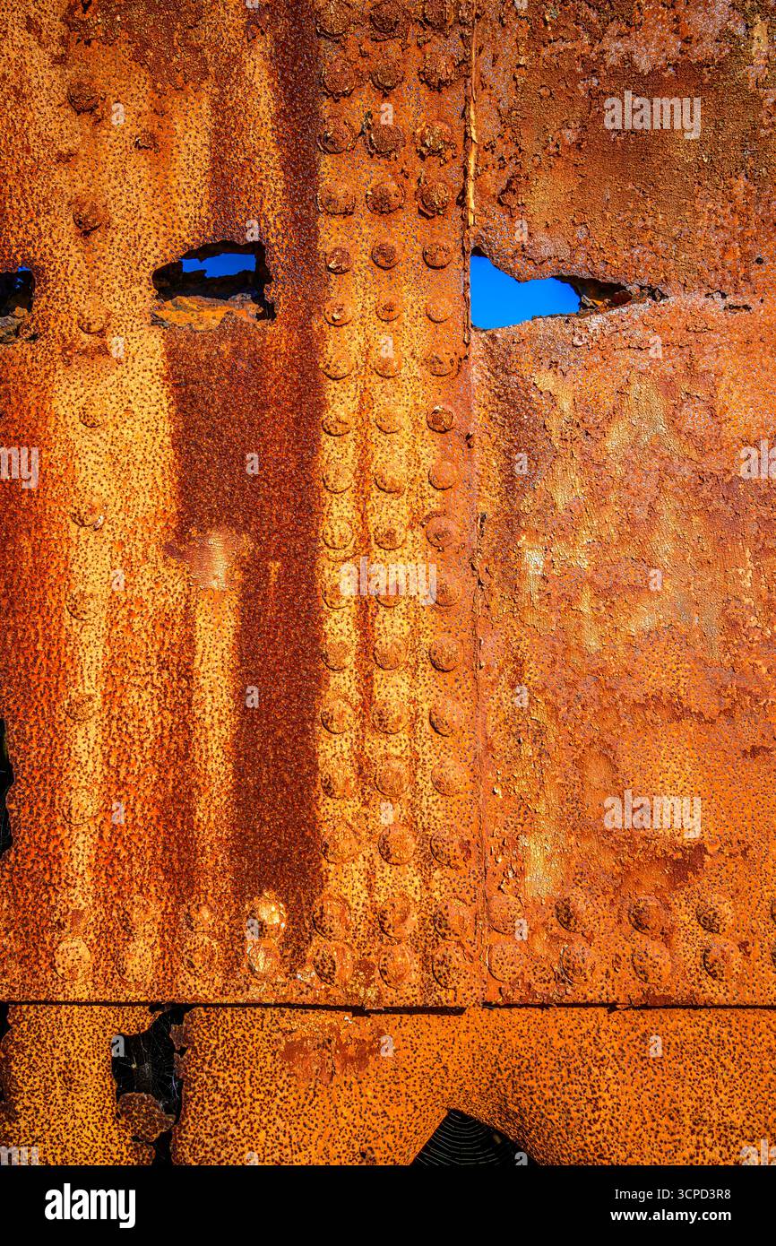 The rough texture of heavily corroded iron plates on the hull of ...
