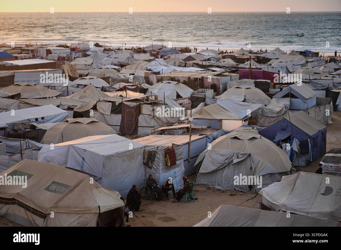Displaced Palestinians sit by their tent in Muwasi, an area that Israel ...