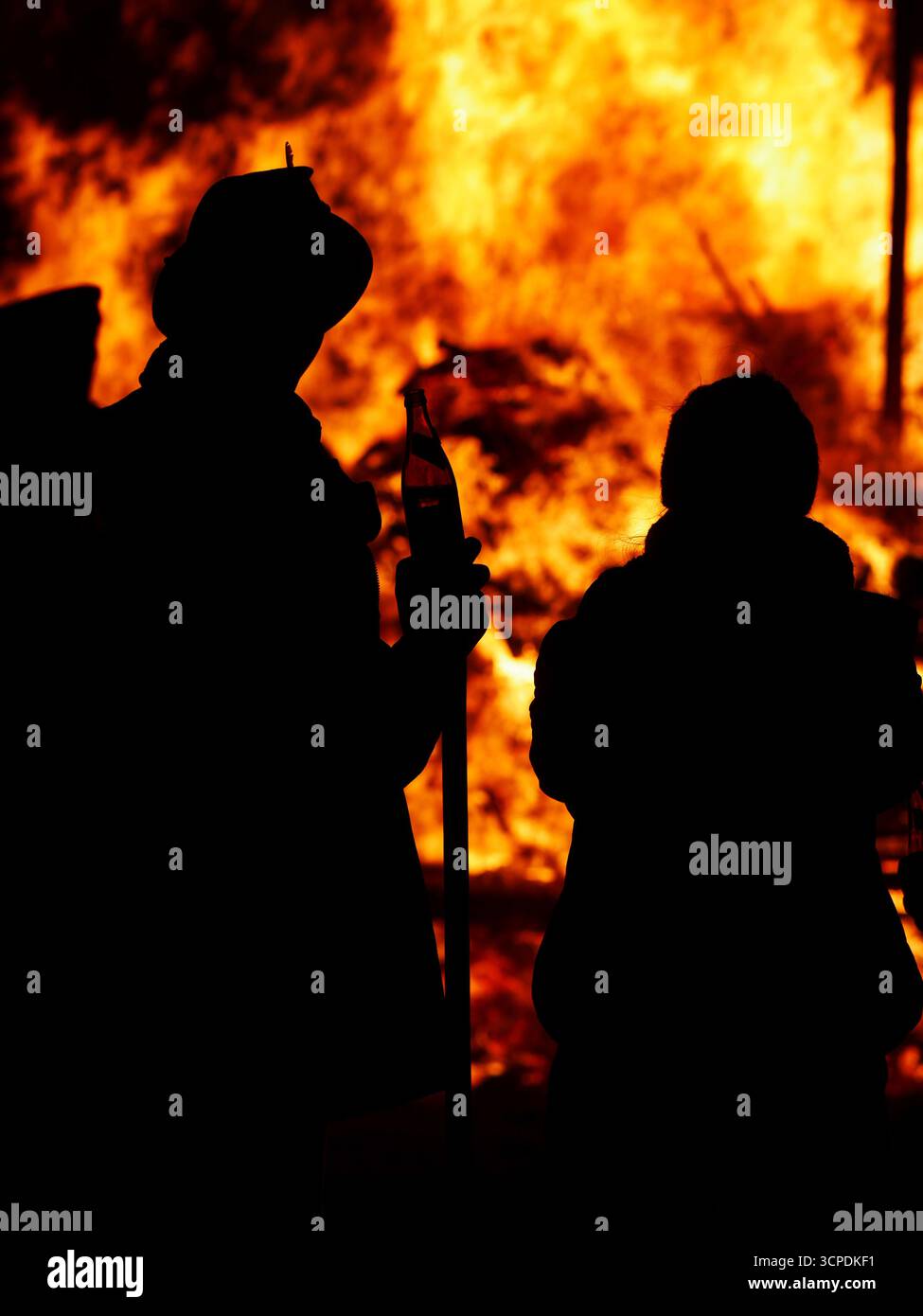 Two firefighters stand in front of a burning building Stock Photo - Alamy