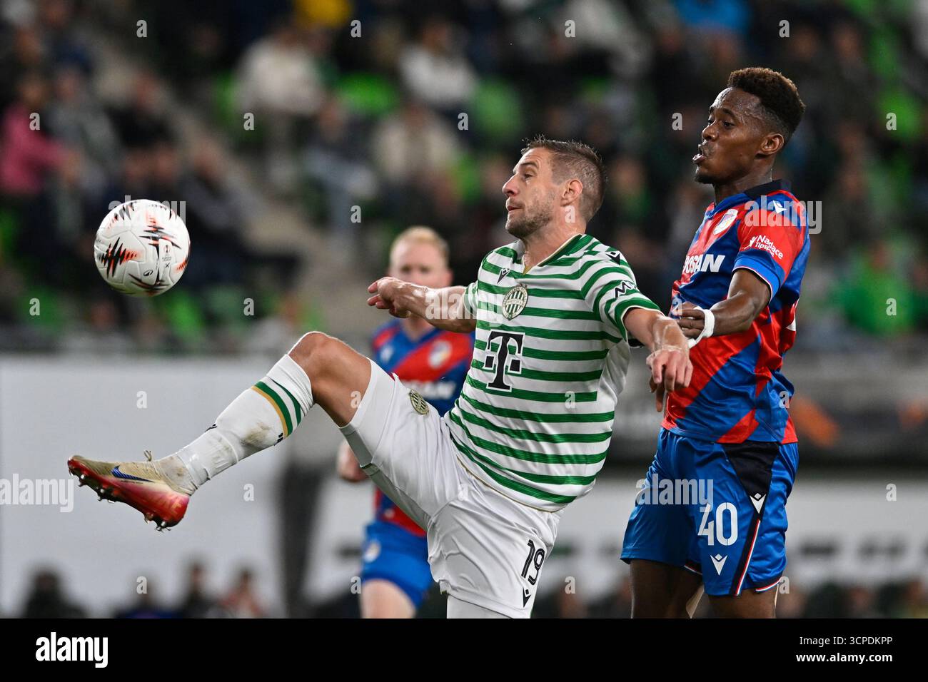 Ferencvaros' Barnabas Varga, centre, kicks the ball ahead of Plzen's ...