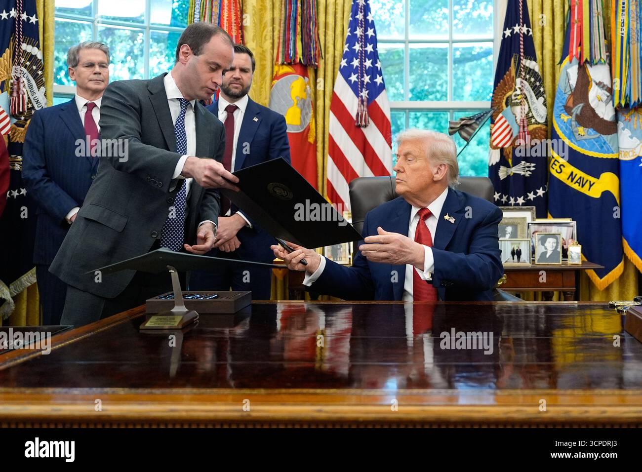 White House staff secretary Will Scharf hands President Donald Trump a ...