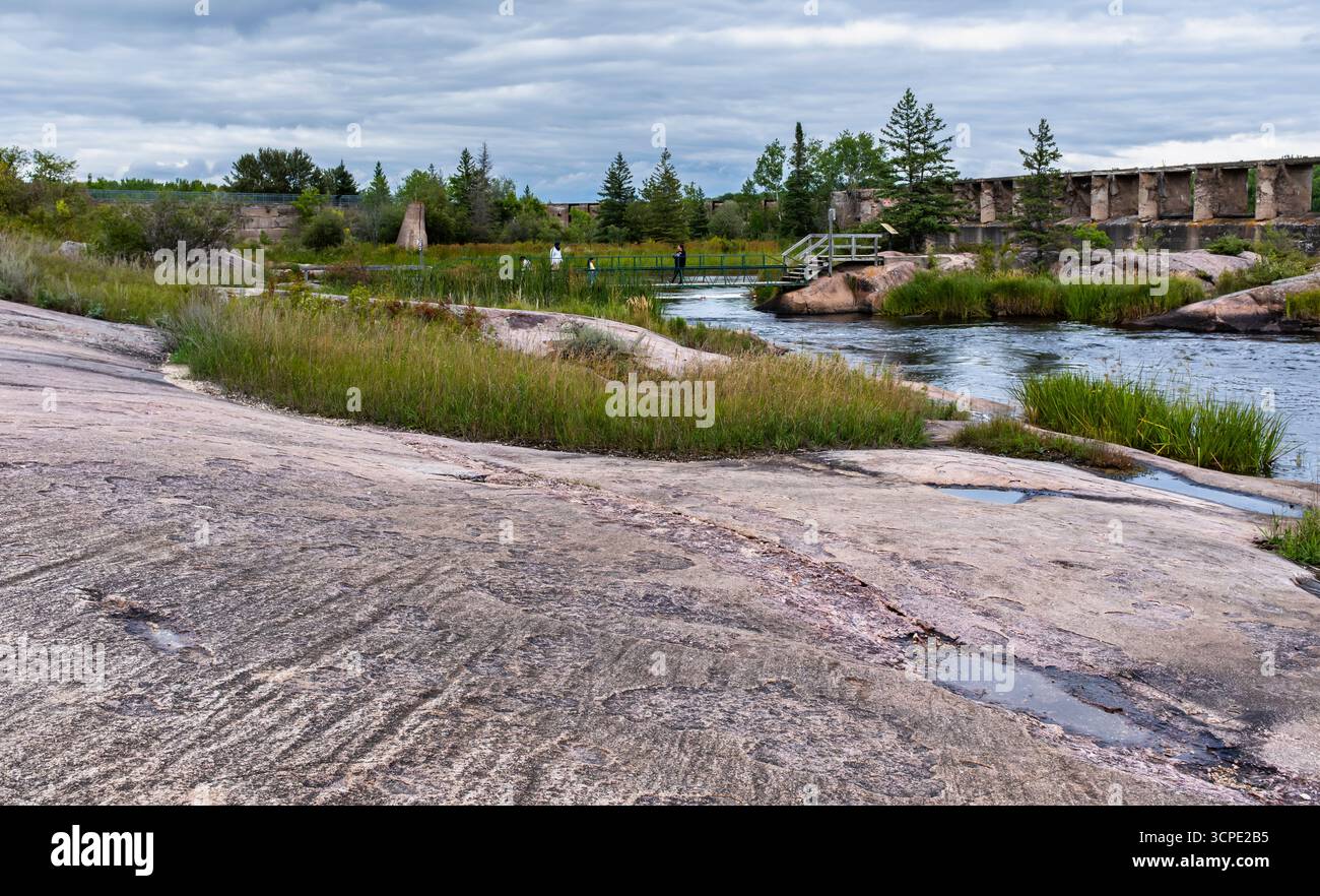 Hikers cross a bridge over the Pinawa Channel with a view of the Pinawa ...