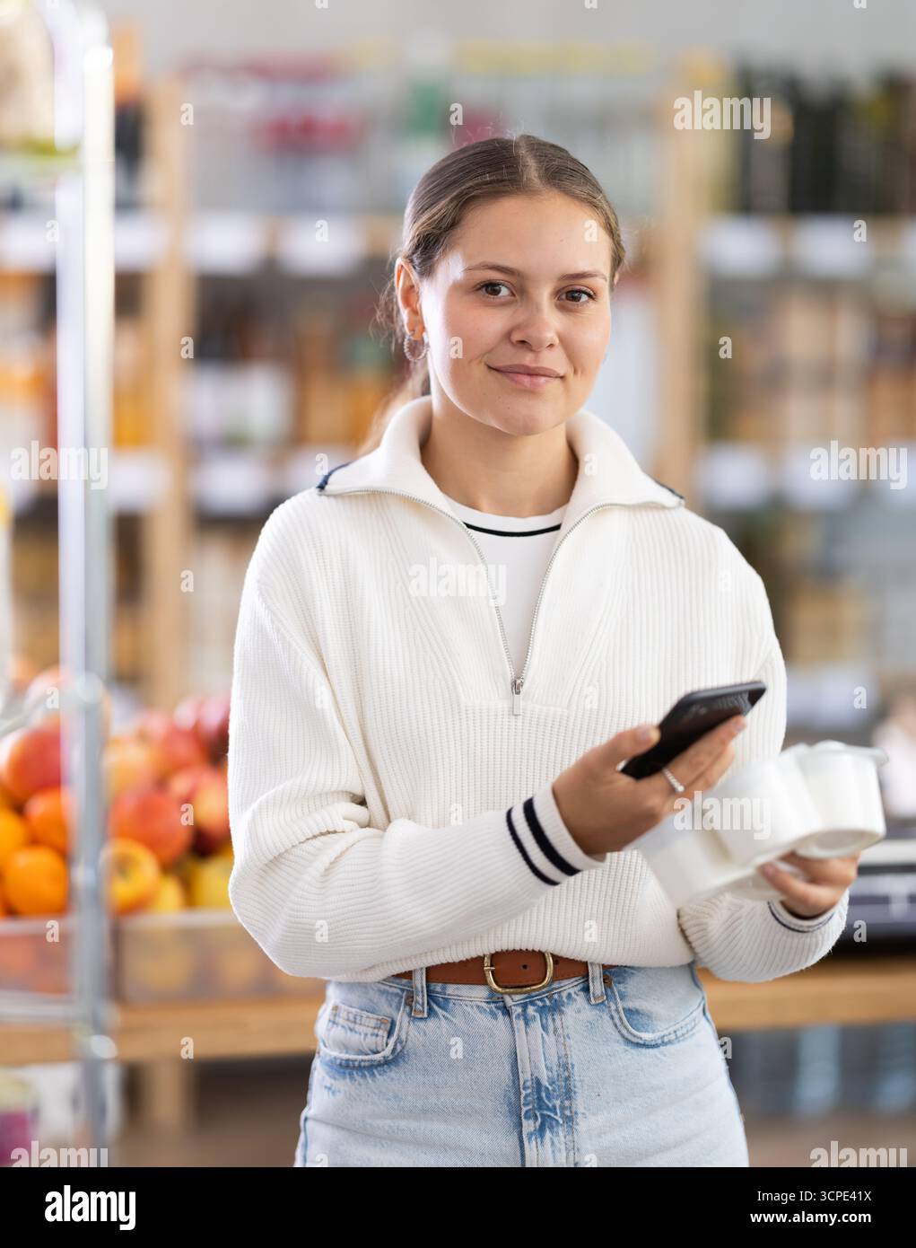 Checking expiration date of yogurt - female shopper scans QR code on ...