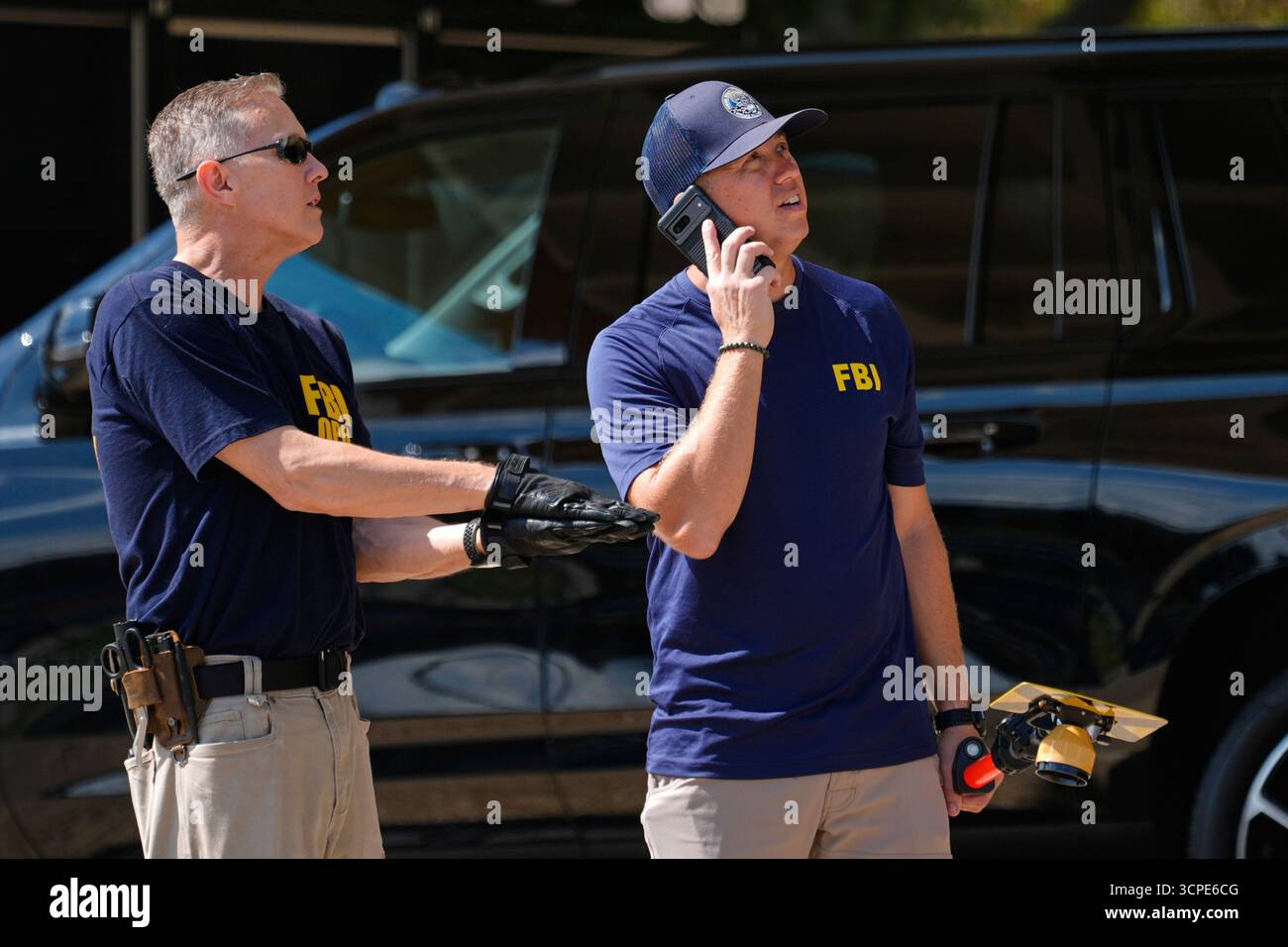 FBI agents investigate the crime scene near a U.S. Immigration and ...
