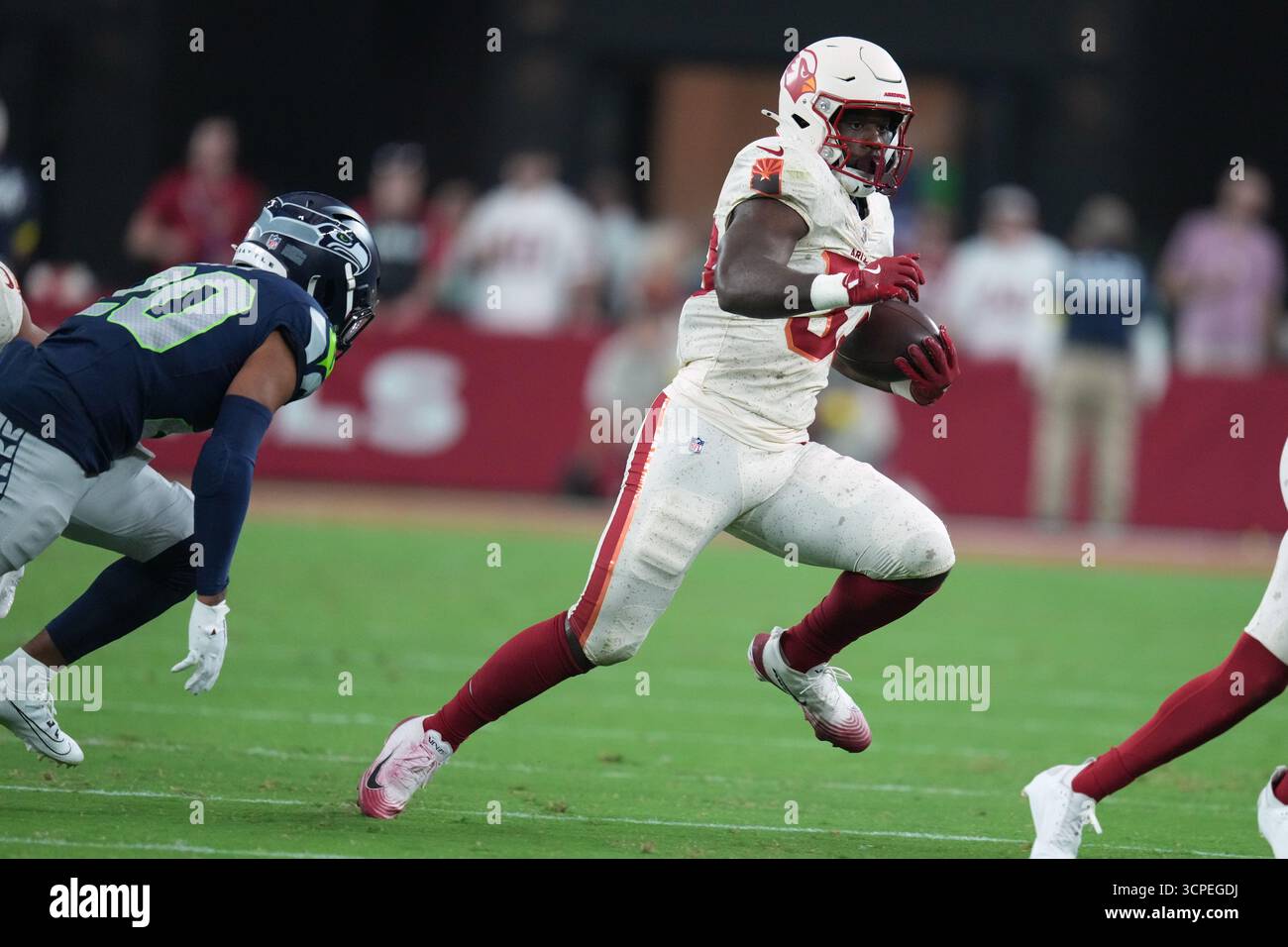 Arizona Cardinals running back Trey Benson, right, runs with the ball ...