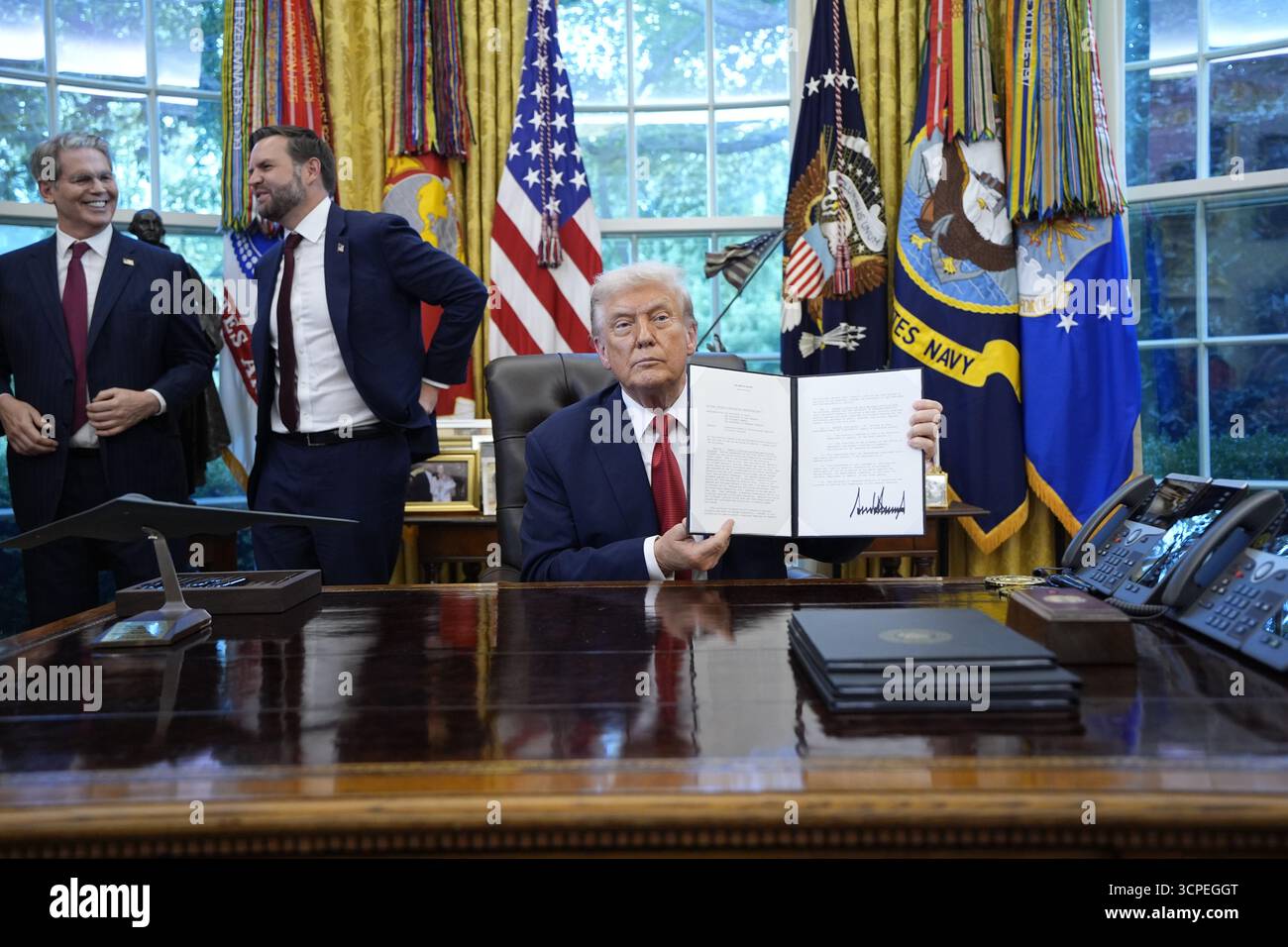 United States President Donald J Trump holds up the first Executive ...