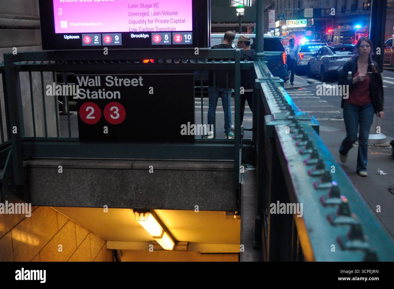 A person walks past the Wall Street subway station in the Financial ...