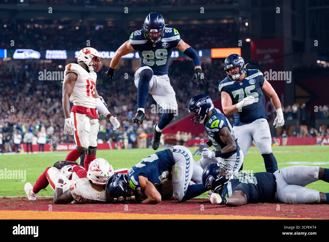 Seattle Seahawks tight end AJ Barner (88) leaps over players during a ...
