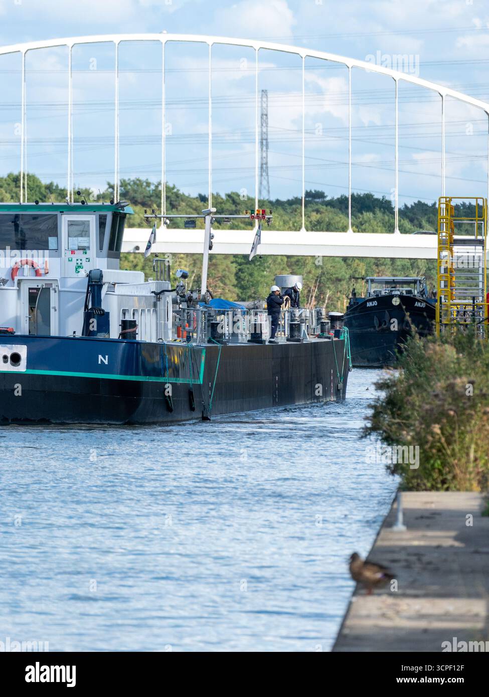 A cargo ship maneuvers sideways towards the modern articulated loading ...