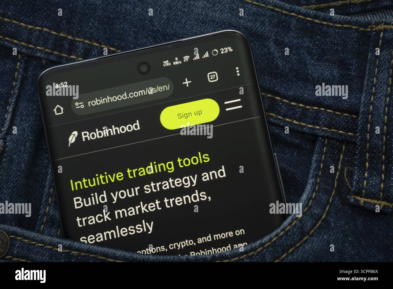Dhaka, Bangladesh- 15 June 2025: A smartphone displaying the Robinhood web interface peeks out ...