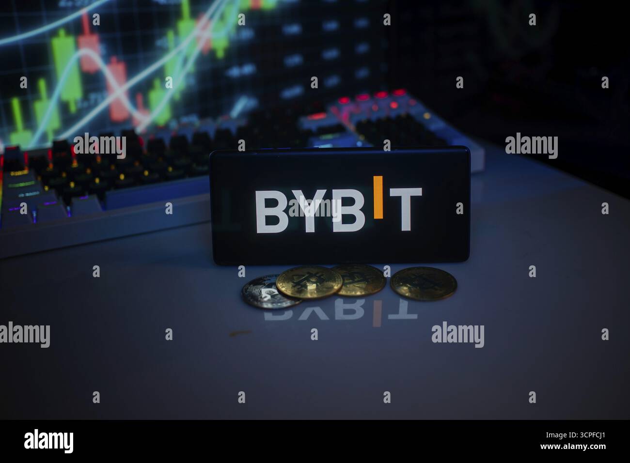 BYBIT logo on smartphone, accompanied by coins and stock chart ...