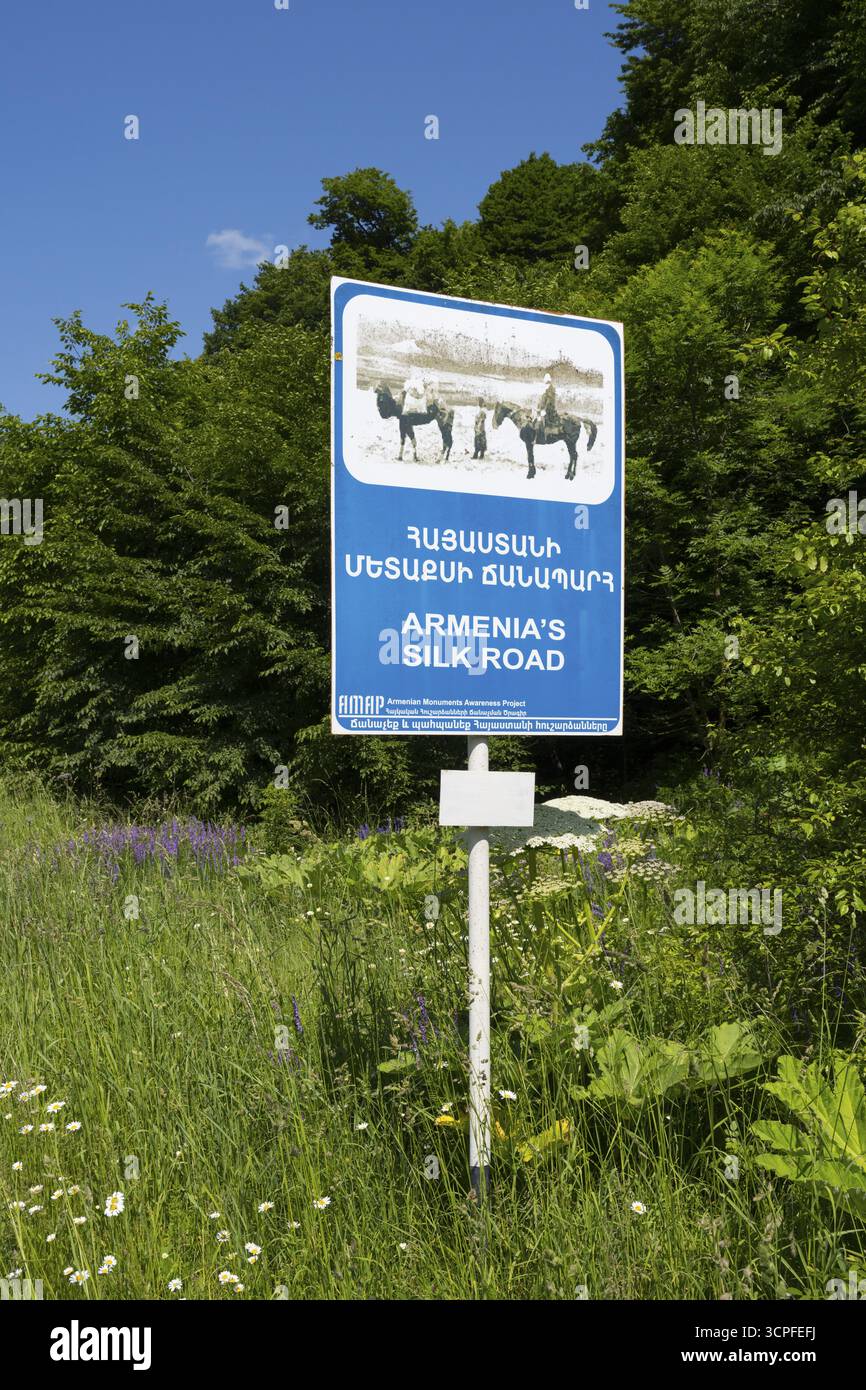 Road sign for Armenia's Silk Road surrounded by green bushes and ...