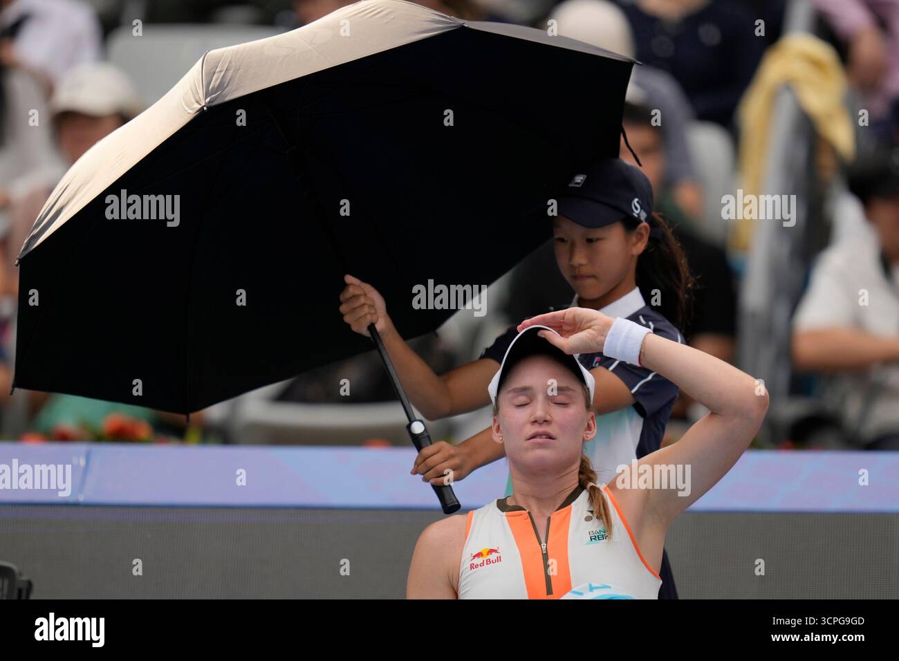 Elena Rybakina of Kazakhstan rests in the shade of an umbrella during a ...