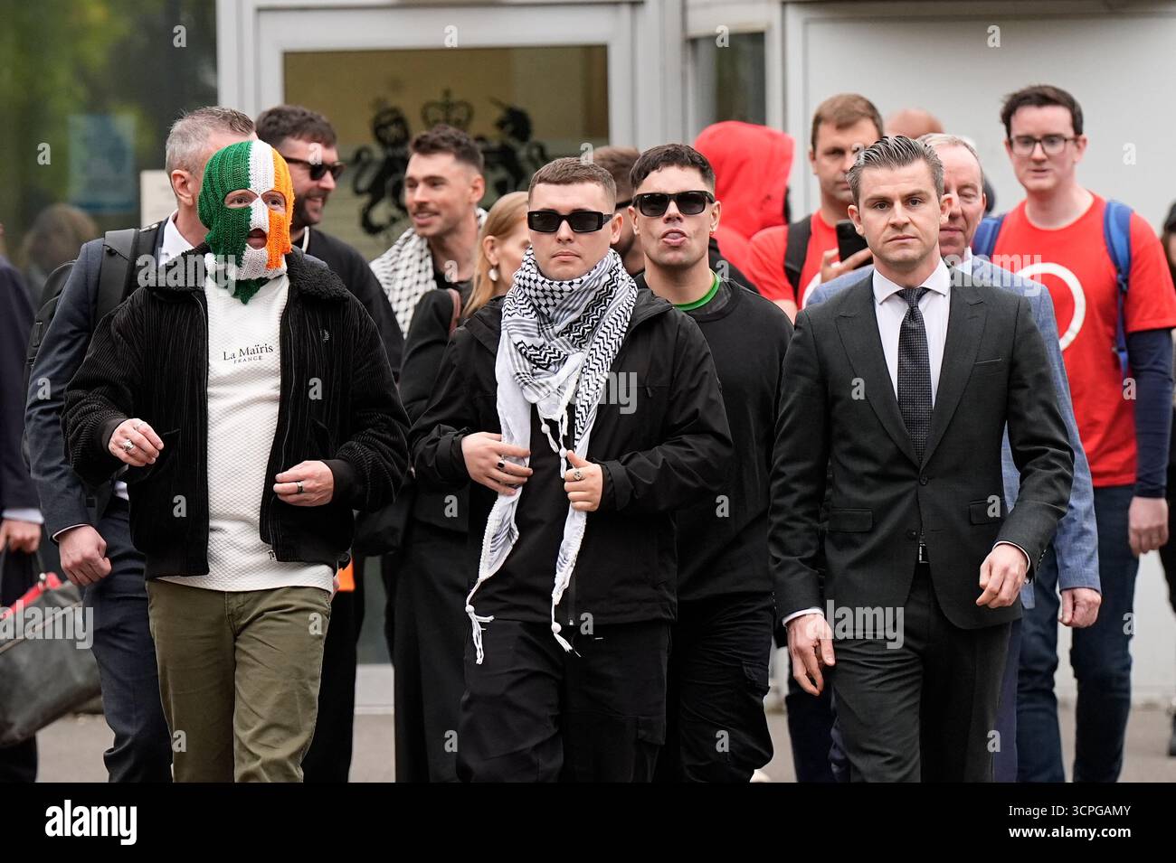 Kneecap's Liam Og O hAnnaidh (centre, in keffiyeh), with his lawyer ...