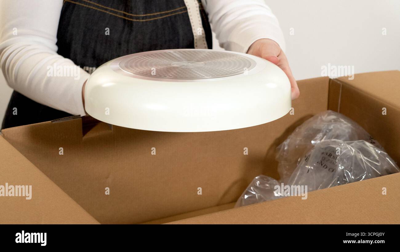Removing White Frying Pan From Box Stock Photo - Alamy