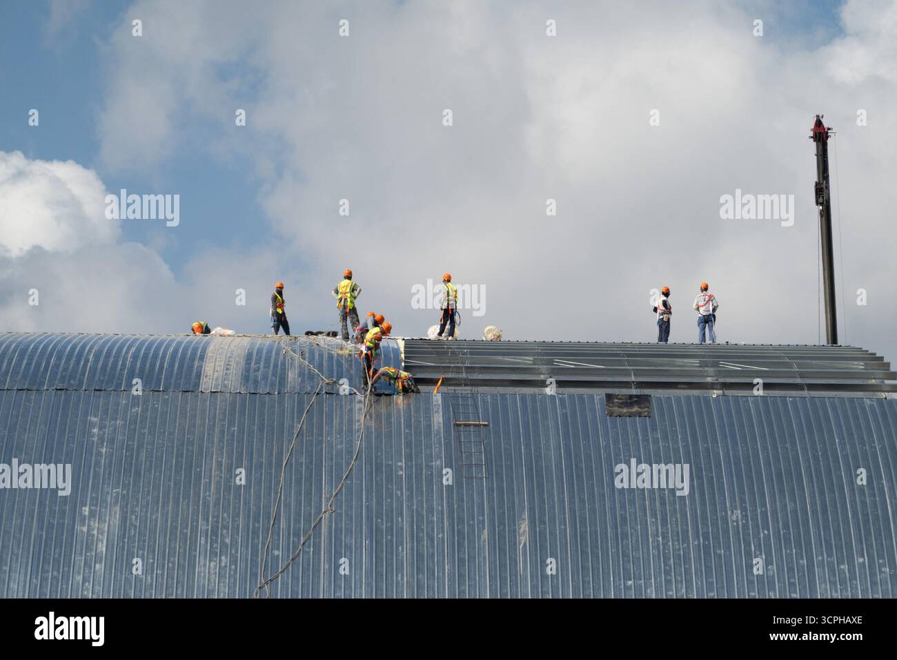 Workers labor on the arch roof of a building under construction in ...