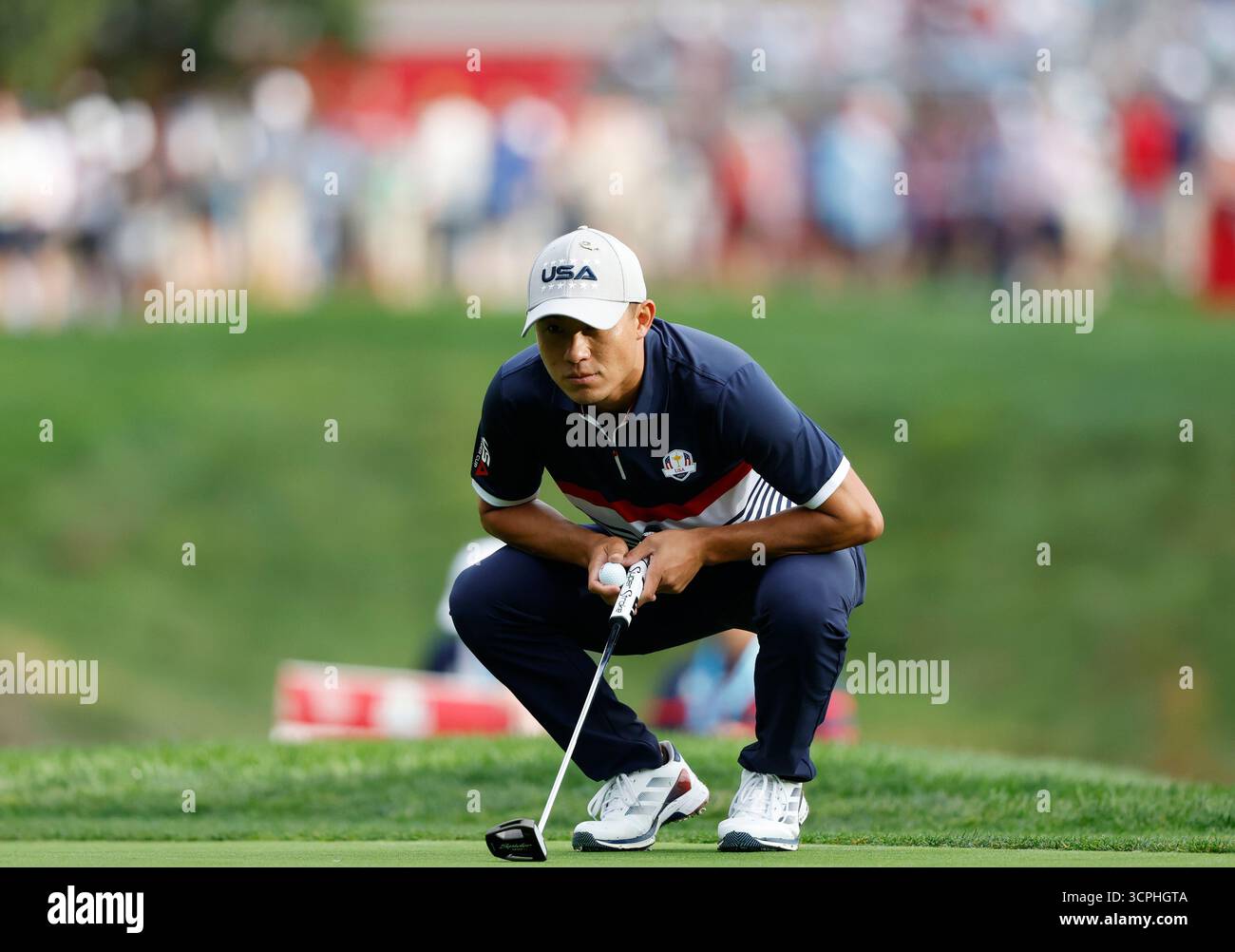 Colin Morikawa of team Unites States lines up a putt on the third hole ...