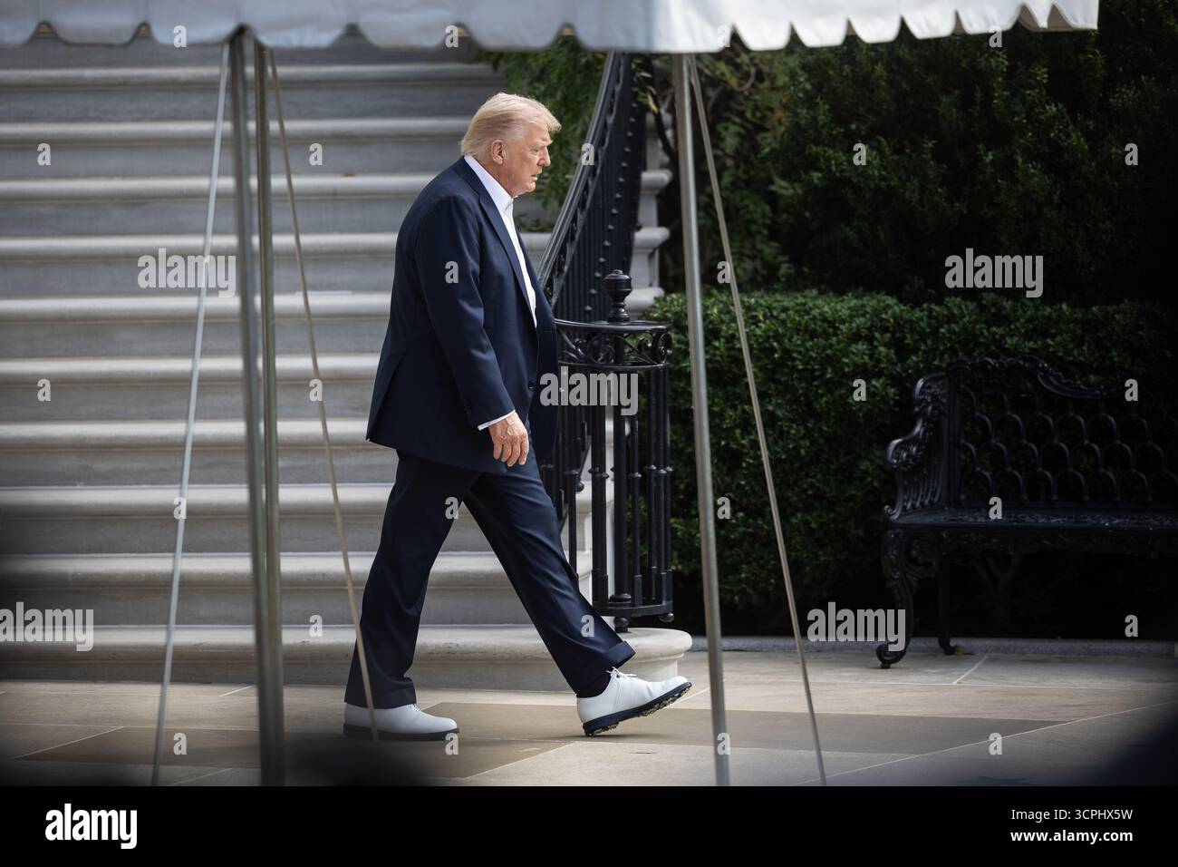 President Donald Trump emerges from the White House on his way to board ...