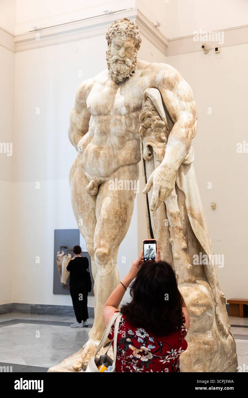 NAPLES, ITALY – AUGUST 2025: Tourists observe the colossal Farnese ...