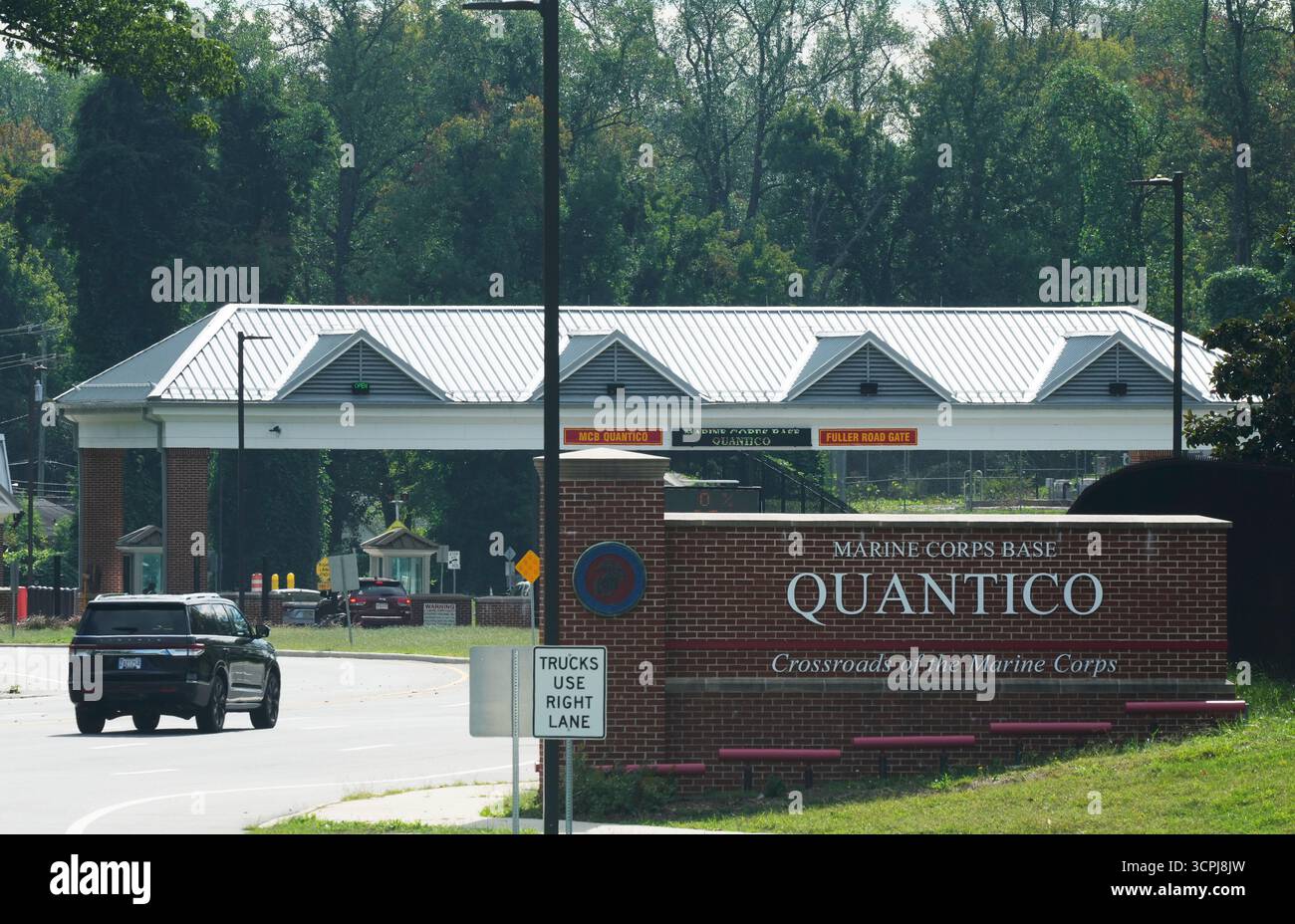 Vehicles drive to the entrance of Marine Corps Base Quantico, Friday ...