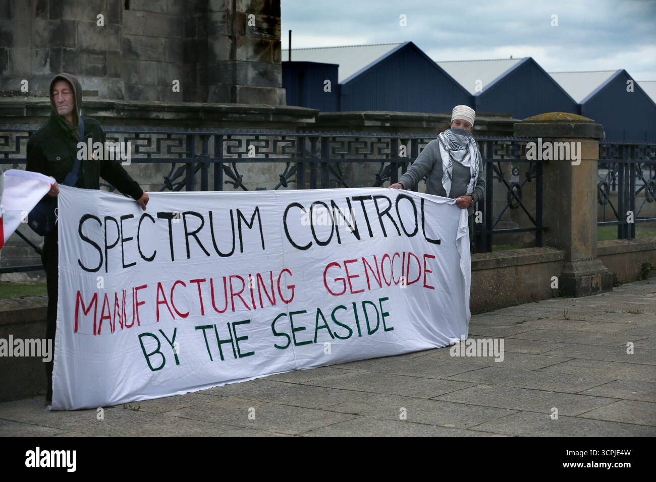 Protesters hold a banner saying ‘Spectrum Control Manufacturing ...