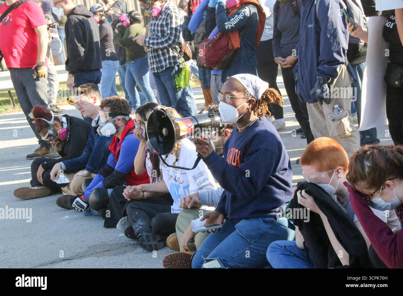 Protesters sit in the driveway to block ICE vehicles from leaving at ...