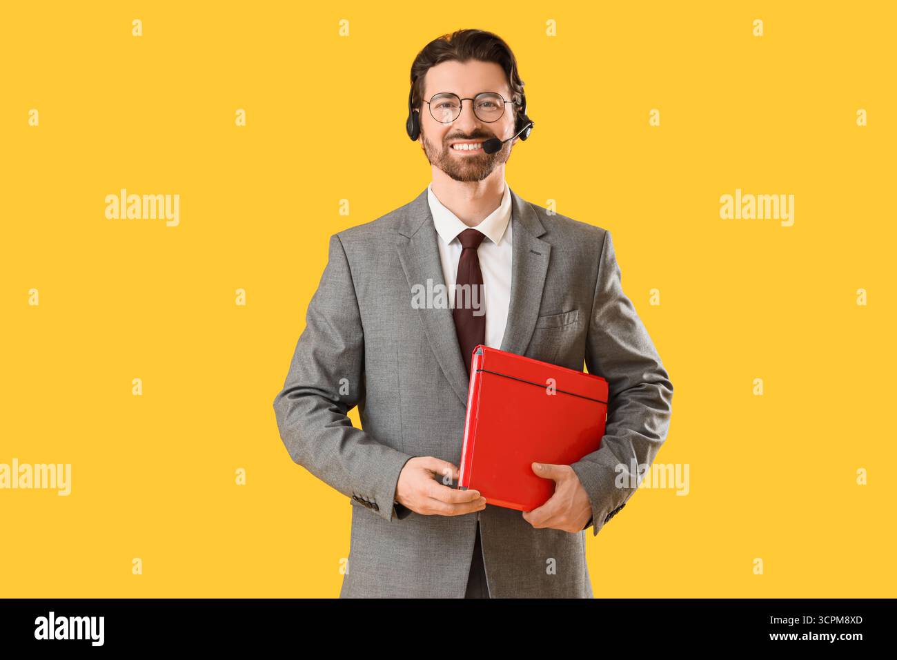 Male secretary in headset with folder on yellow background Stock Photo ...