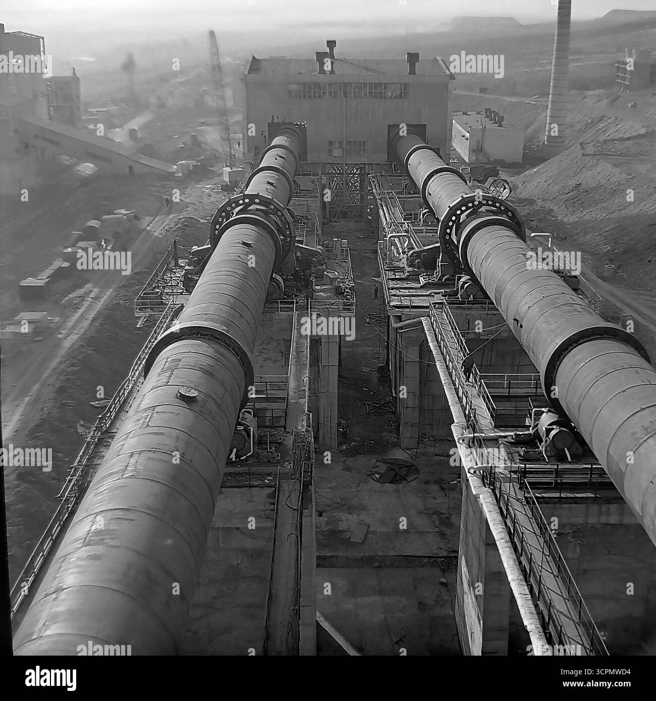 An elevated panoramic view shows the massive parallel rotary kilns of a ...