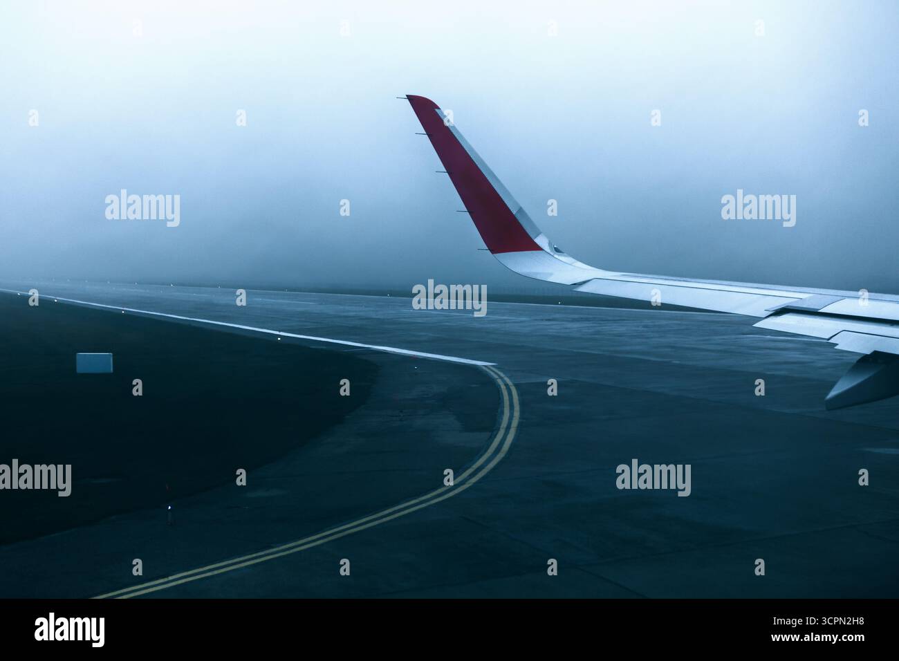 Airplane wing is visible as the aircraft sits on a runway shrouded in ...