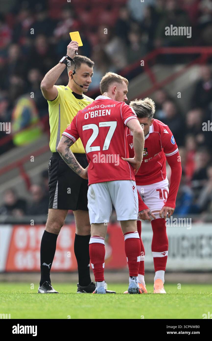 Referee Tom Nield shows Wrexham’s Lewis O'Brien a yellow card during ...