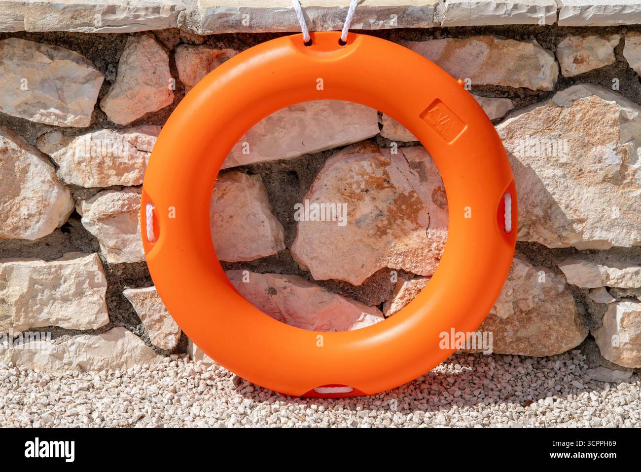 bright orange lifebelt or life ring hanging on a wall for use in a ...
