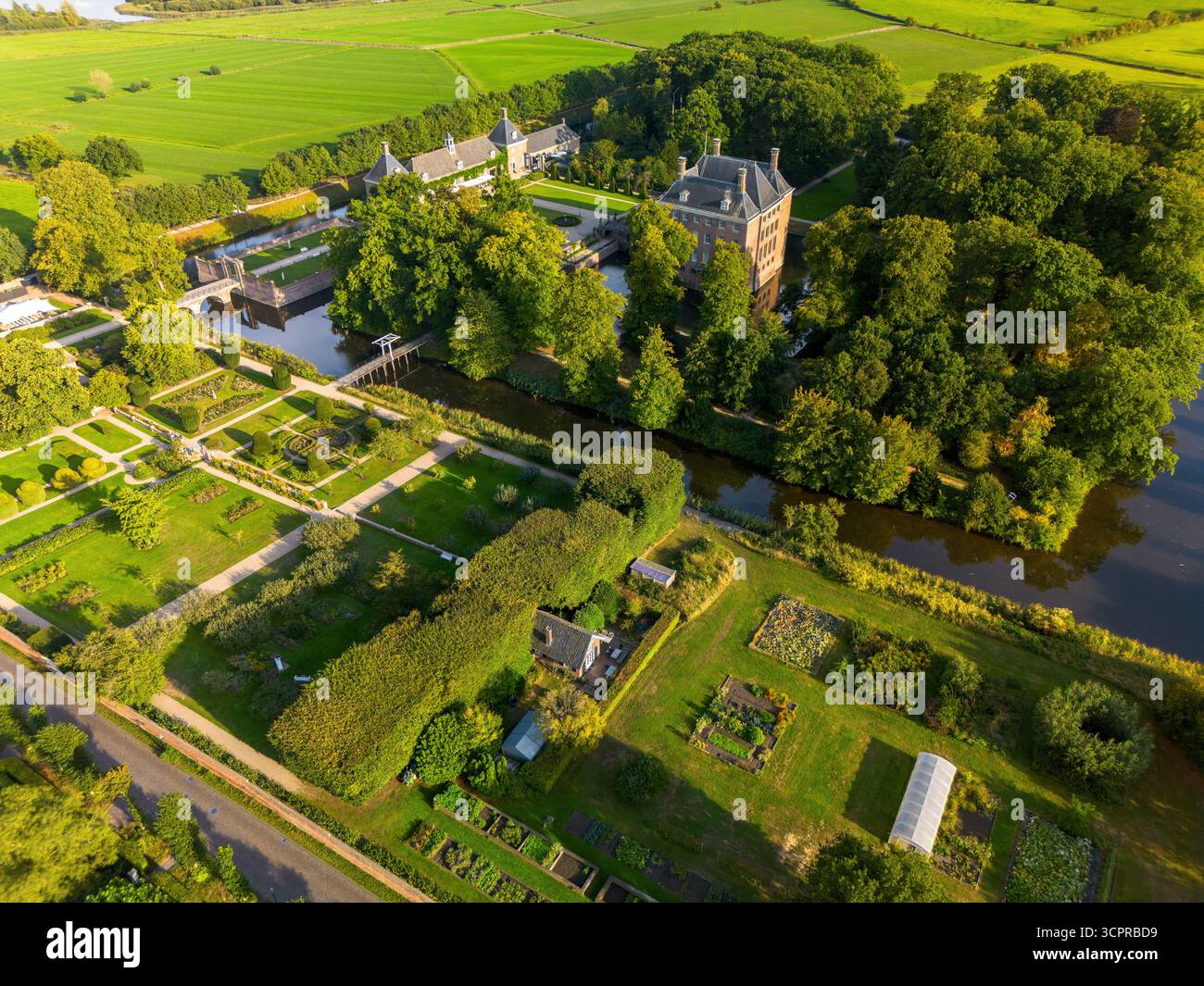 Aerial view of moated castle estate with formal gardens, greenhouses ...