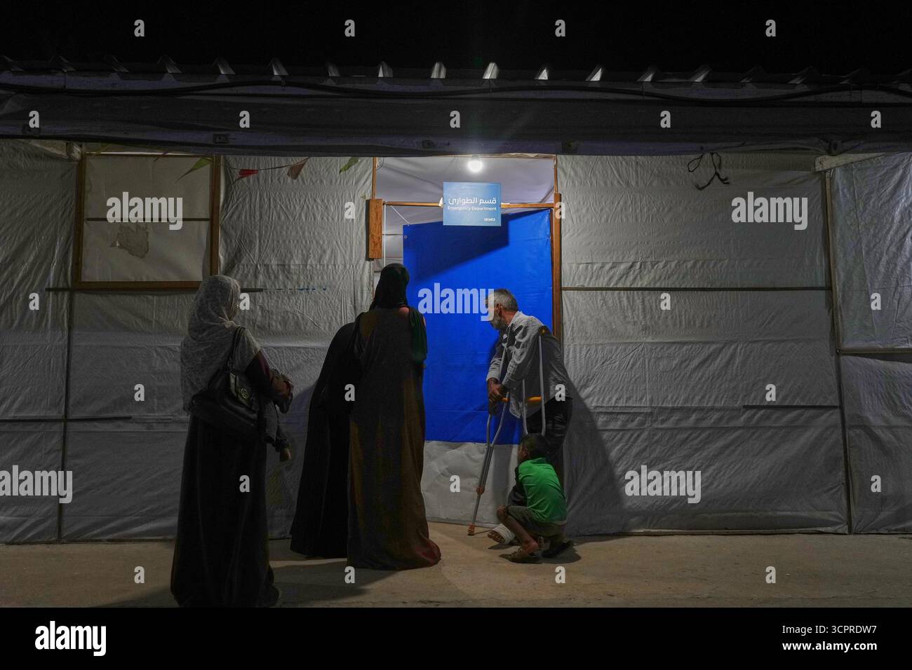 Patients wait outside a field hospital of the British humanitarian ...