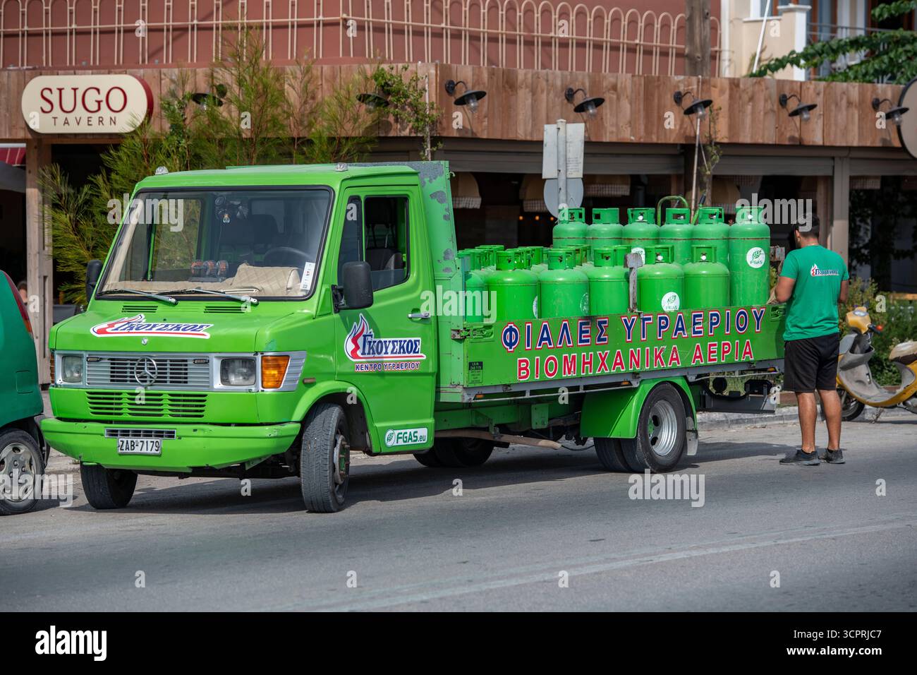 Man delivering portable gas cannisters or bottles from the back of open ...