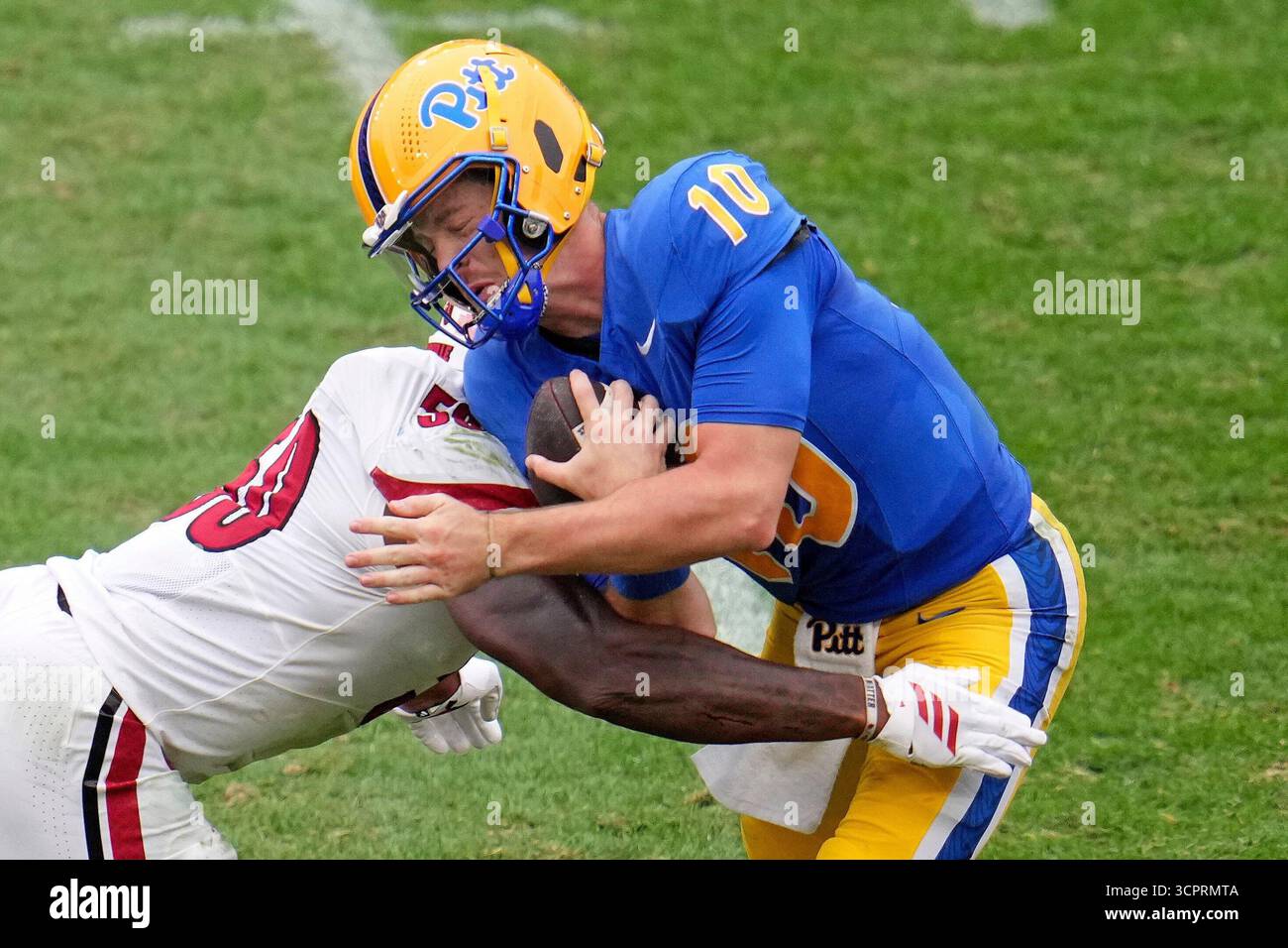 Pittsburgh quarterback Eli Holstein (10) is tackled by Louisville ...