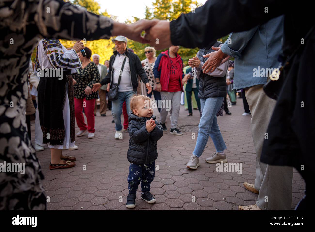 Dragos, one year old, claps as people dance during a weekly dance event ...