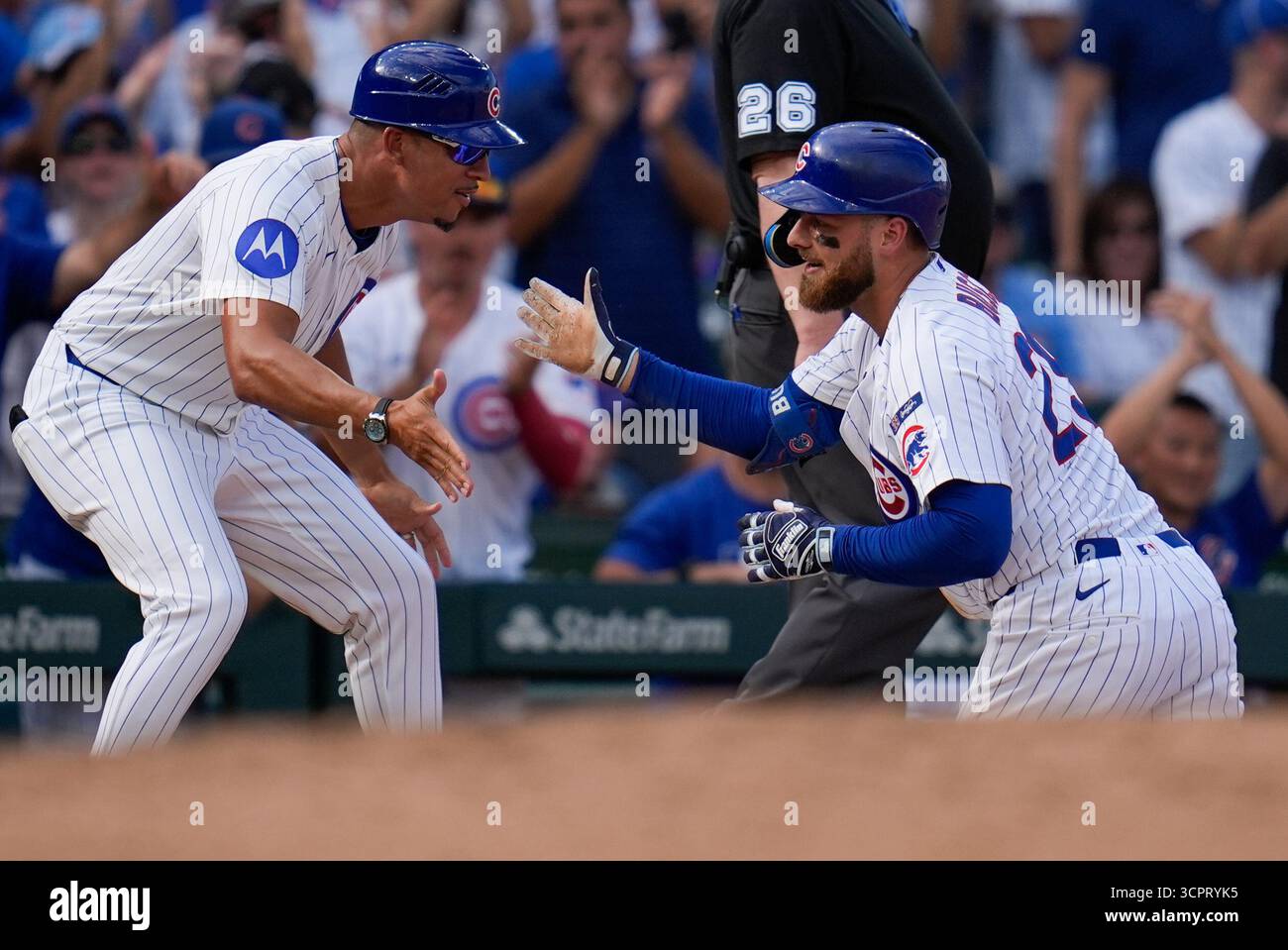 Chicago Cubs' Michael Busch, right, high-fives third base coach Quintin ...