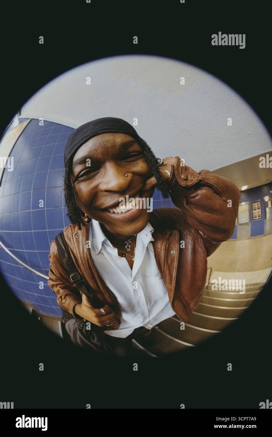 Fish Eye Lens portrait of playful young man wearing bandana standing in ...